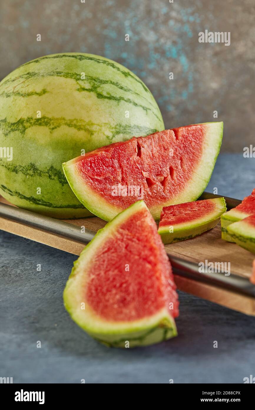 Mini pastèque avec des tranches de quartiers sur un support en bois sur ...
