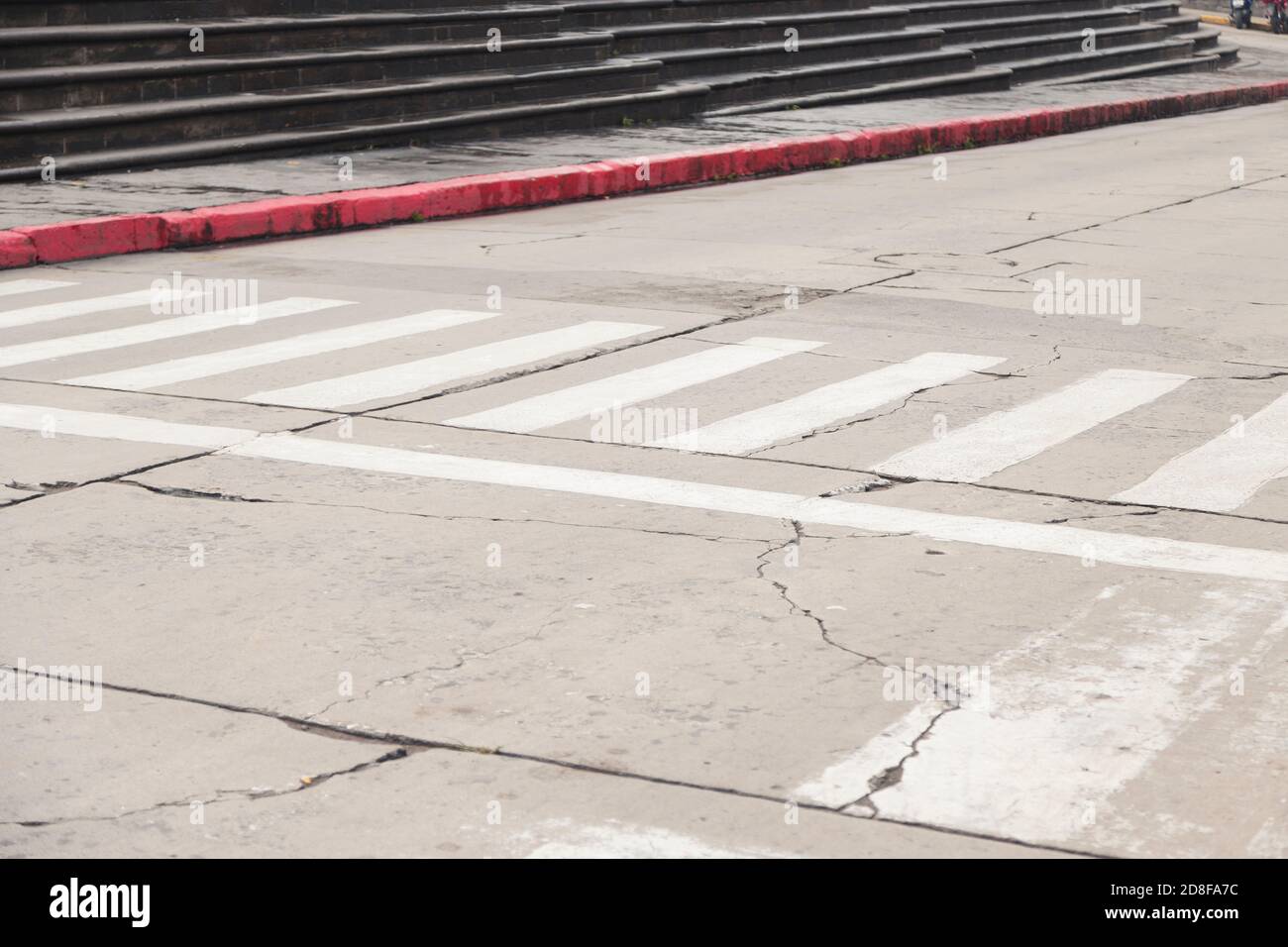 Lignes de passage de zébra blanc sur la route ancienne et brisée ...