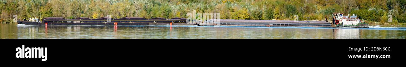 Bateau-pousseur avec barges sur le Danube navigue le long de la forêt ...