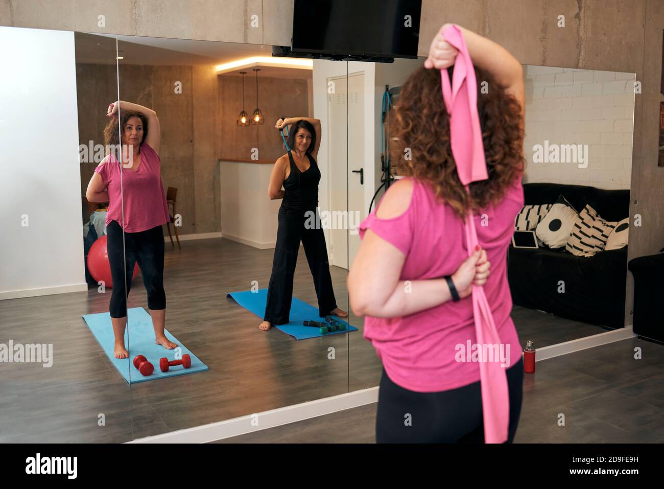 Deux femmes d'âge moyen font des exercices d'étirement à la maison ... Deux femmes d'âge moyen font des exercices d'étirement à la maison ...