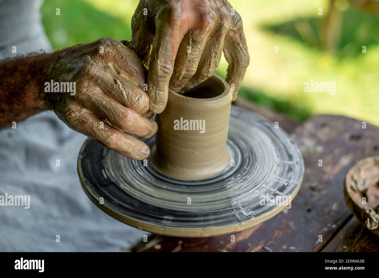 Mains d'un potier façonnant un pot d'argile sur un roue de potier Photo ...