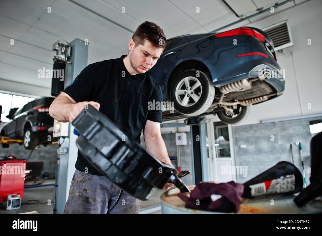 Thème de réparation et d'entretien de voiture. Mécanicien en uniforme travaillant en service ...