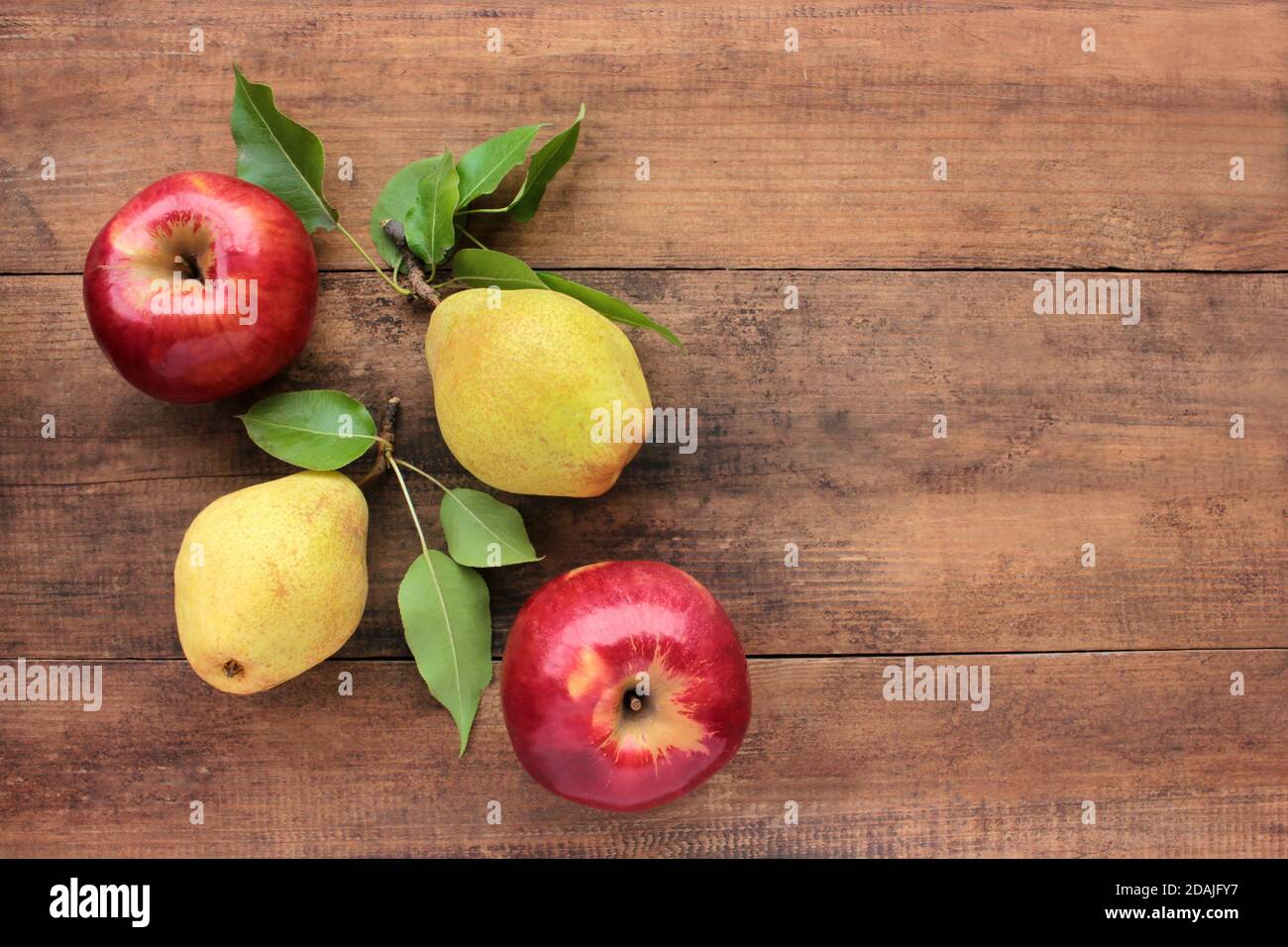 Pommes rouges naturelles et poires jaunes avec feuilles sur une ...
