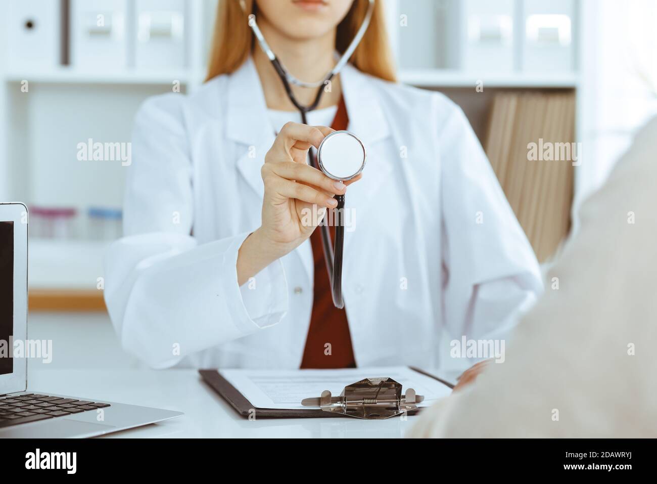 Femme-médecin inconnue avec un stéthoscope dans les mains. Le médecin ...