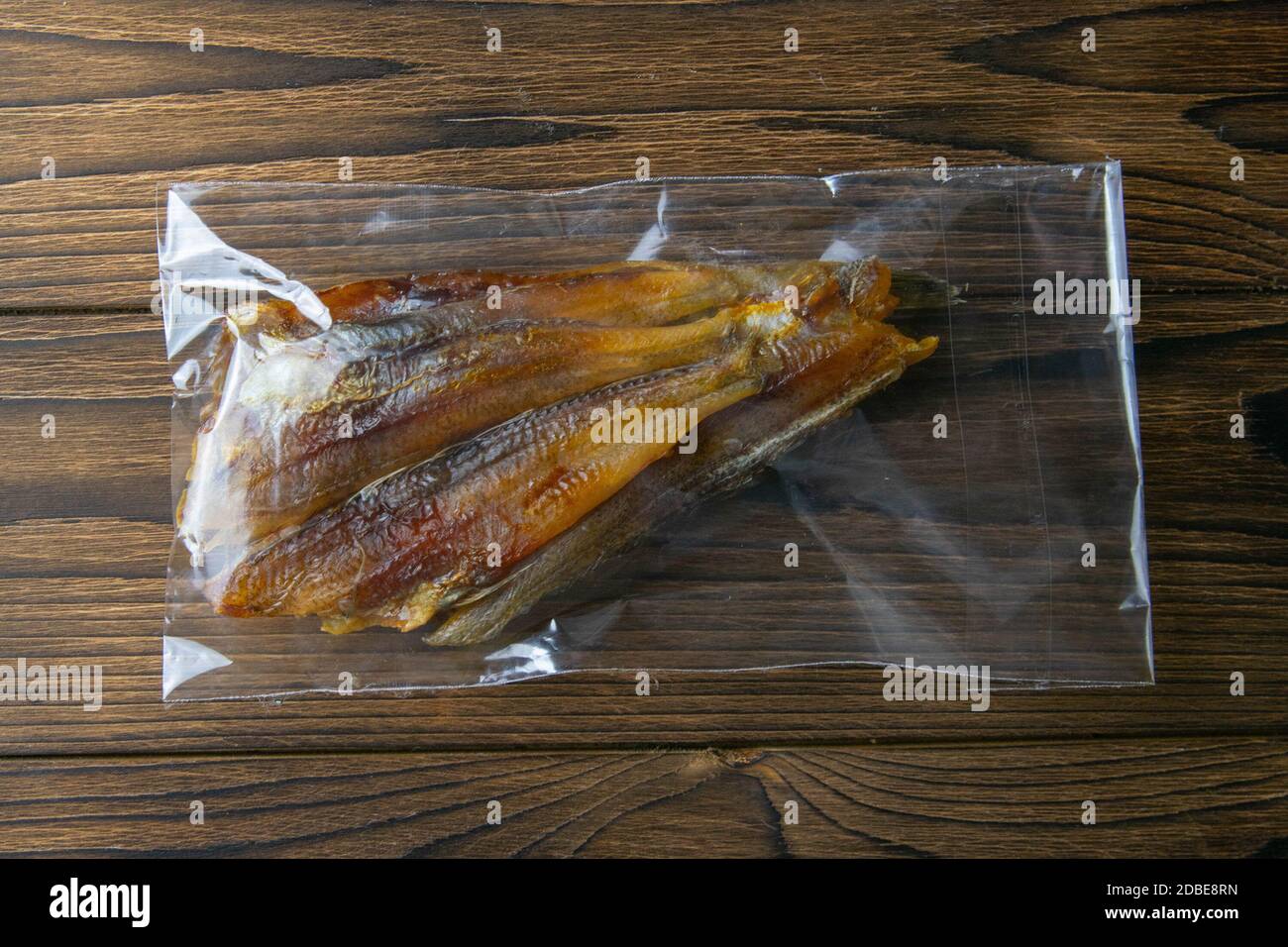 Poisson merlan bleu séché dans un emballage transparent apéritif à la ...