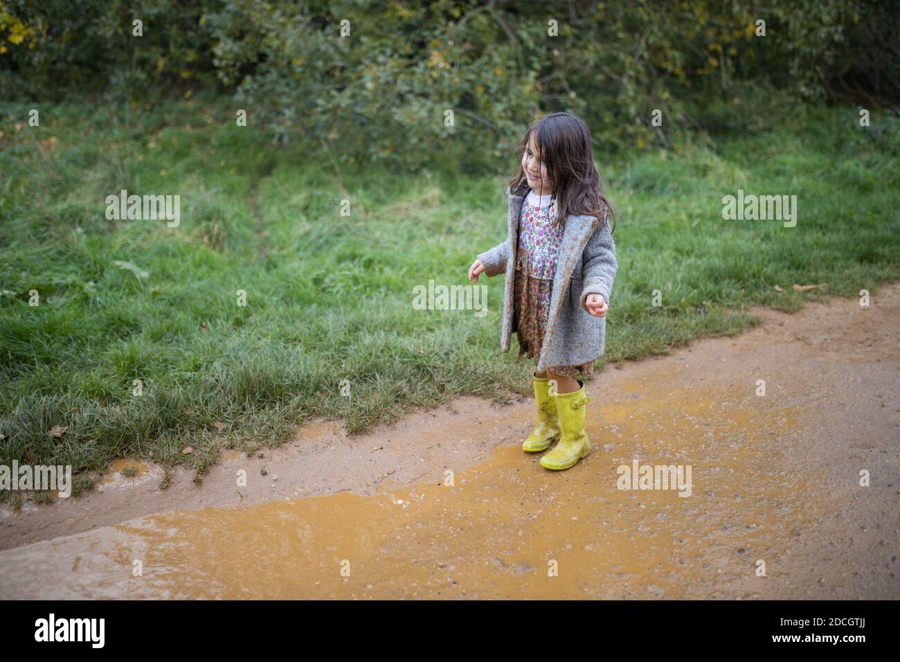 Fille sautant dans une flaque d'eau boueuse Banque de photographies et ...