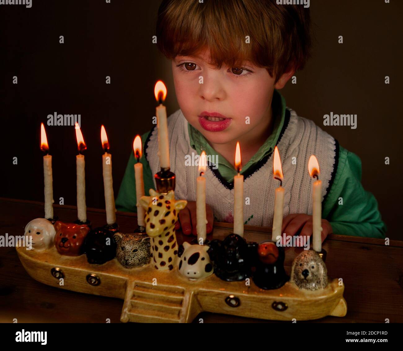 Le jeune garçon et sa mère éclairent les bougies de la menorah pendant ...
