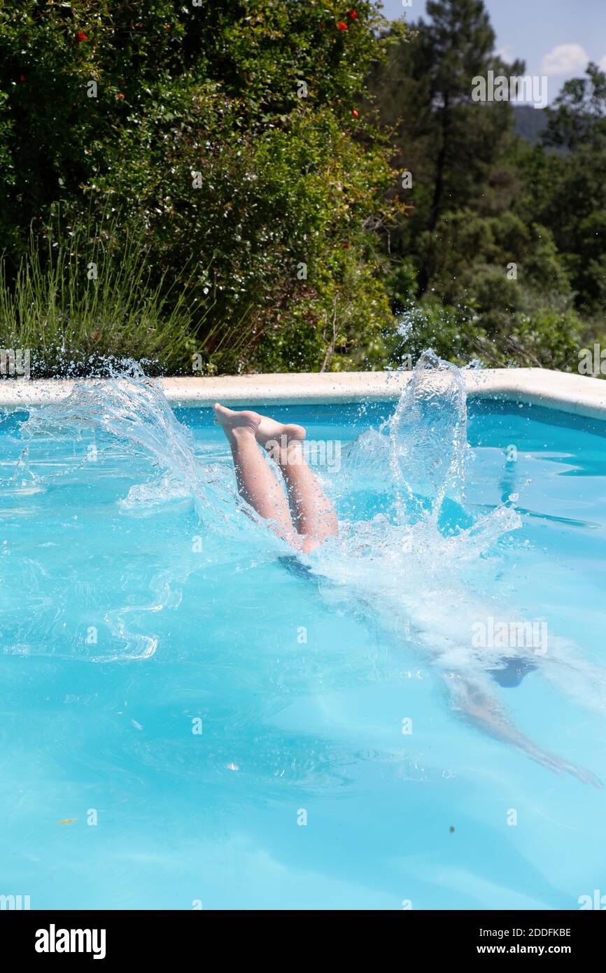 Un Jeune Garçon Saute Dans Leau Bleue Claire De La Piscine Personne