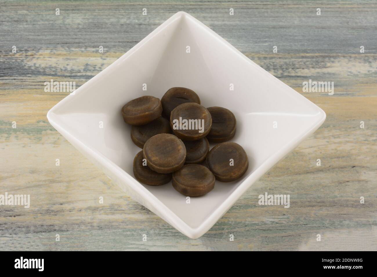 Bonbon dur à saveur de Coca-Cola rond dans un plat de bonbons blanc ...