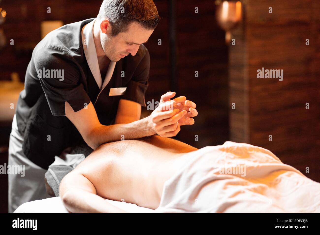 Masseur professionnel faisant un massage profond du dos à un homme ...