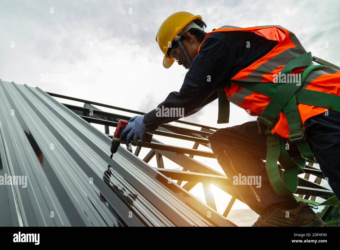 Construction de toit, un travailleur asiatique installe un nouveau toit ...