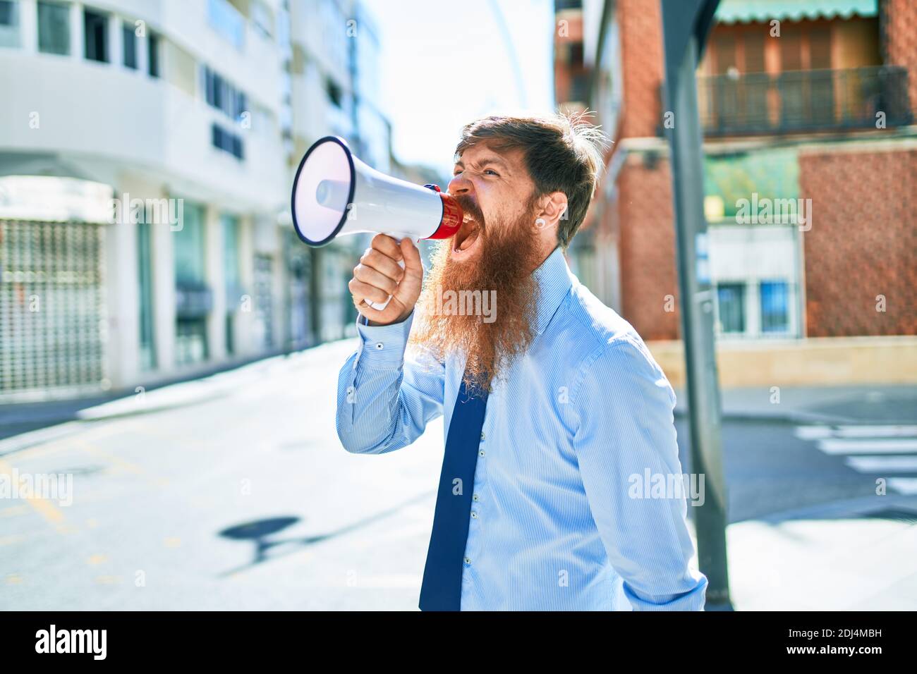 Jeune homme d'affaires à la tête rouge avec expression en colère. Crier ...