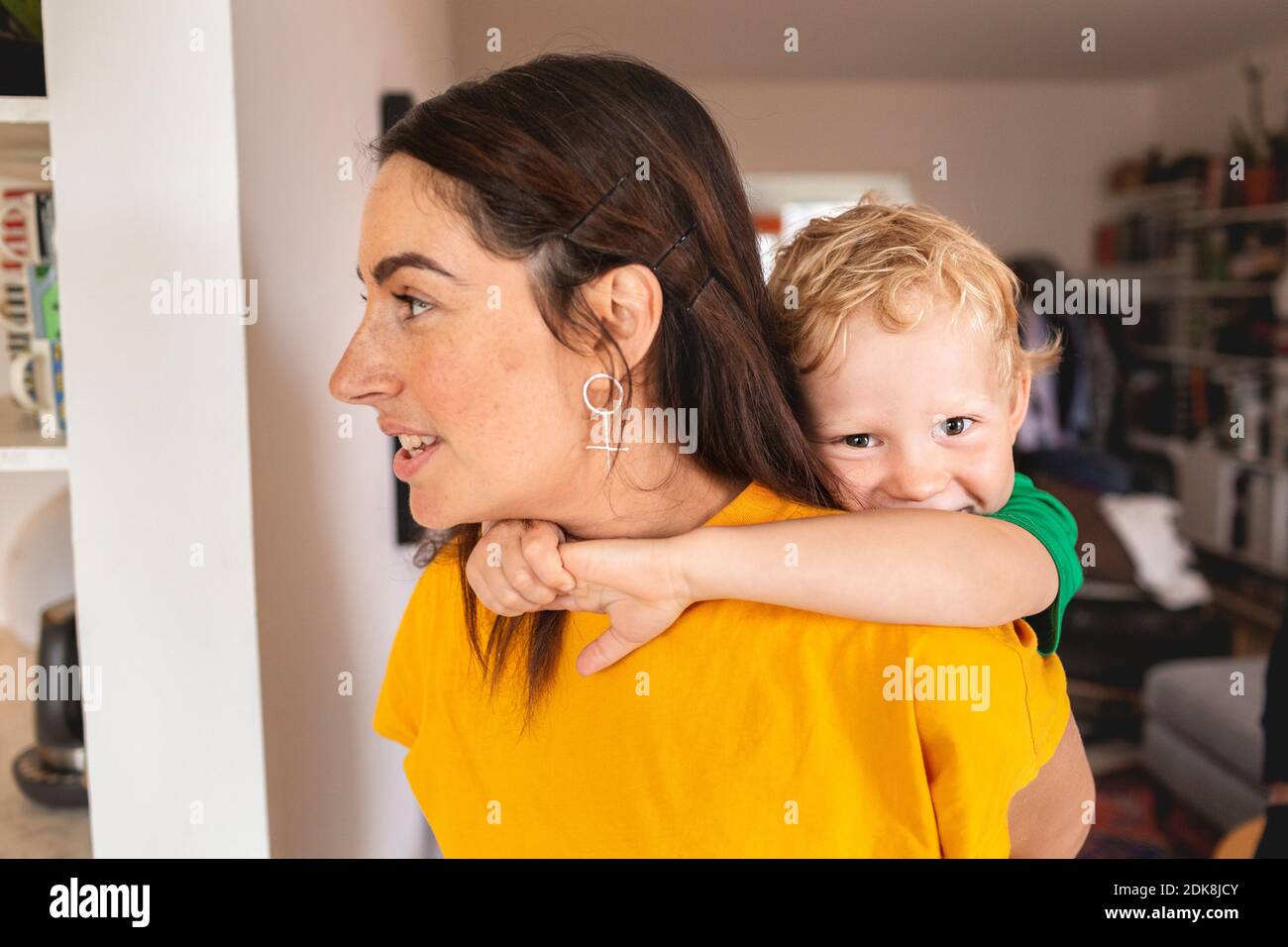 Femme Portant Son Fils Sur Le Dos Et Souriant Banque De Photographies