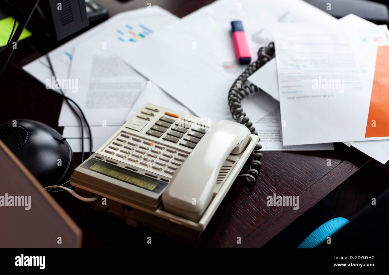 Mess sur un bureau, téléphone, beaucoup de papiers et de documents d ...