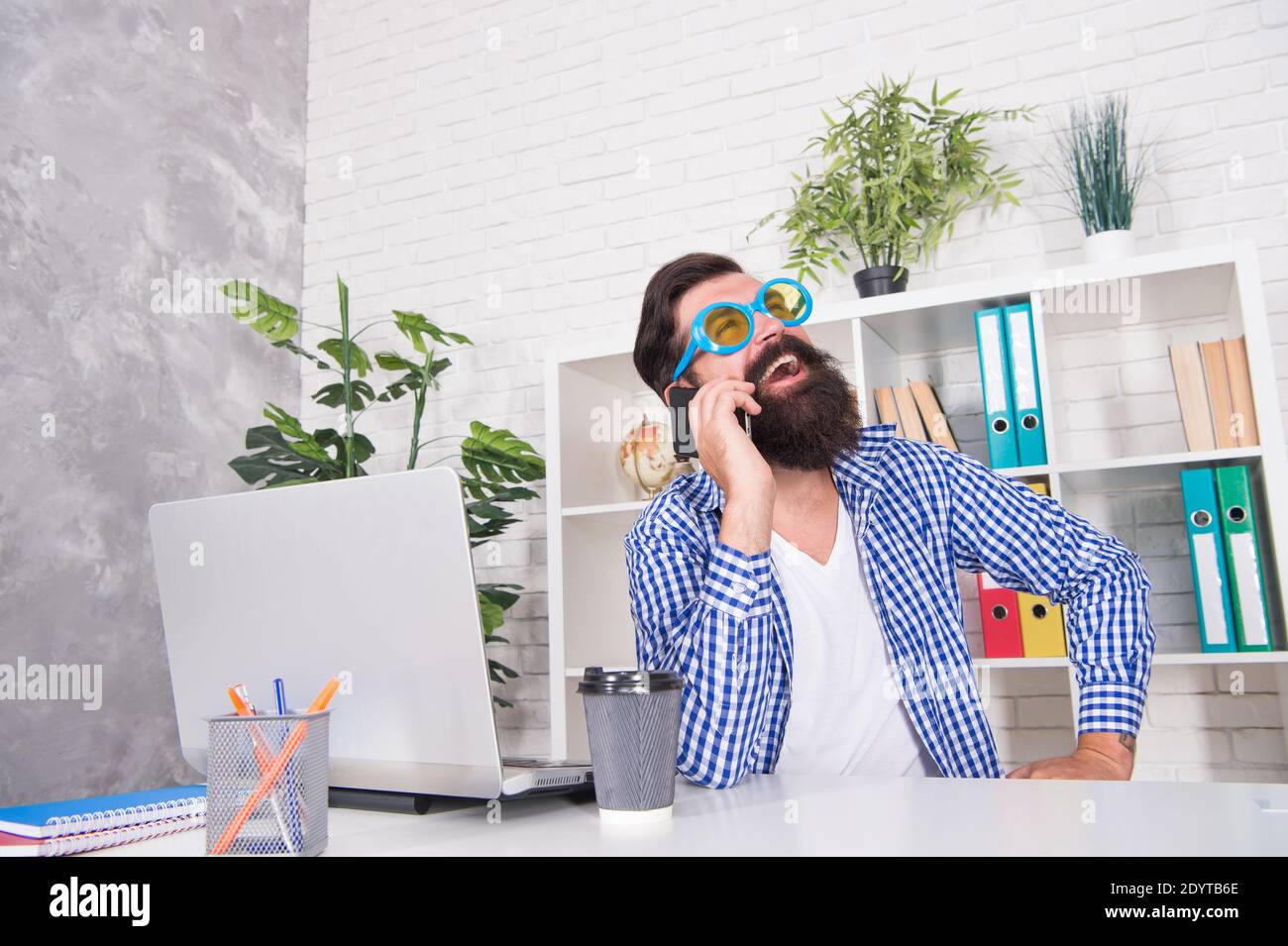 Comment puis-je vous aider ? Un homme barbu parle au téléphone portable ...