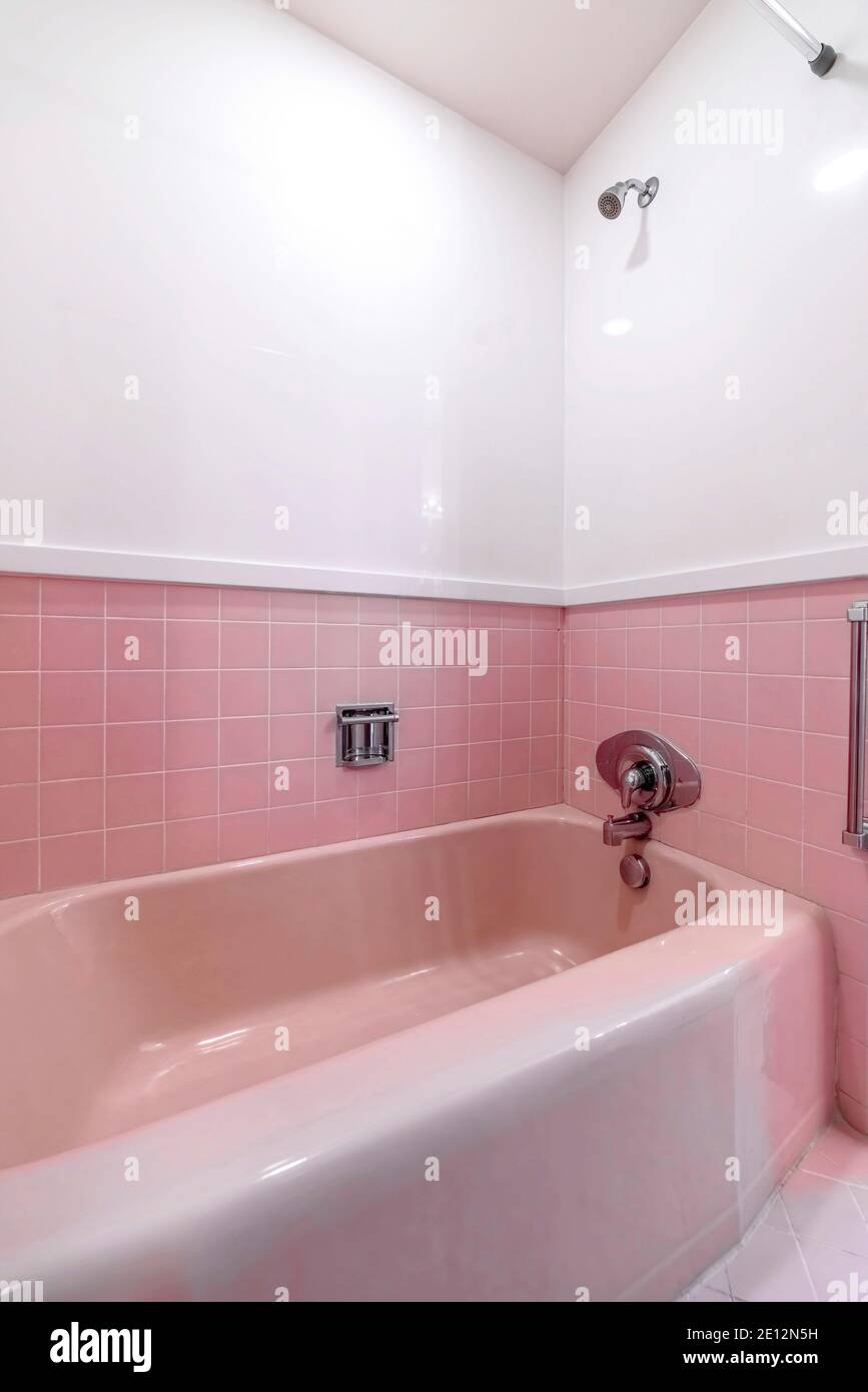 Baignoire rose à l'intérieur d'une salle de bains résidentielle avec ...