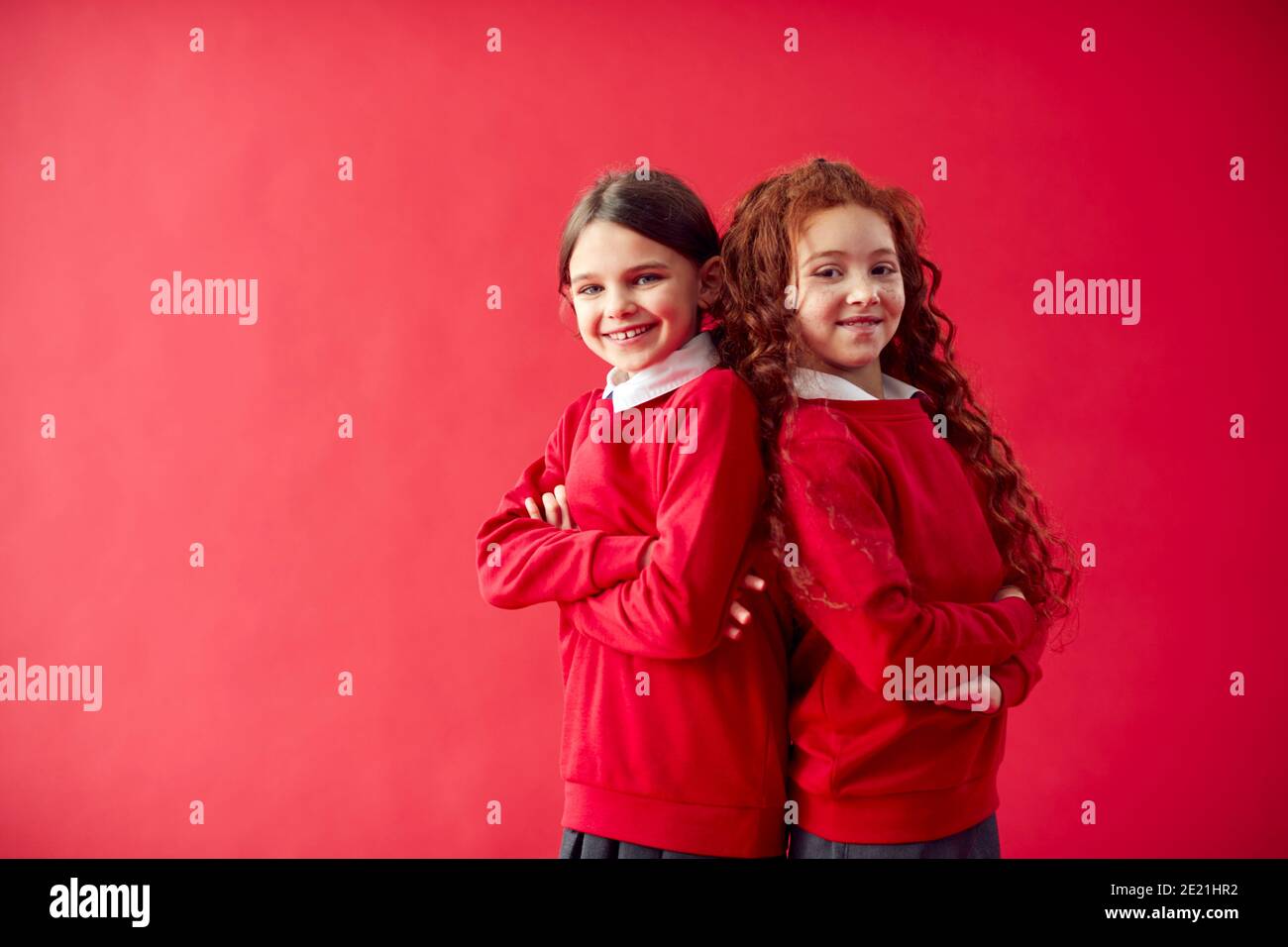 Deux élèves de l'école élémentaire portent un uniforme dos à dos contre ...
