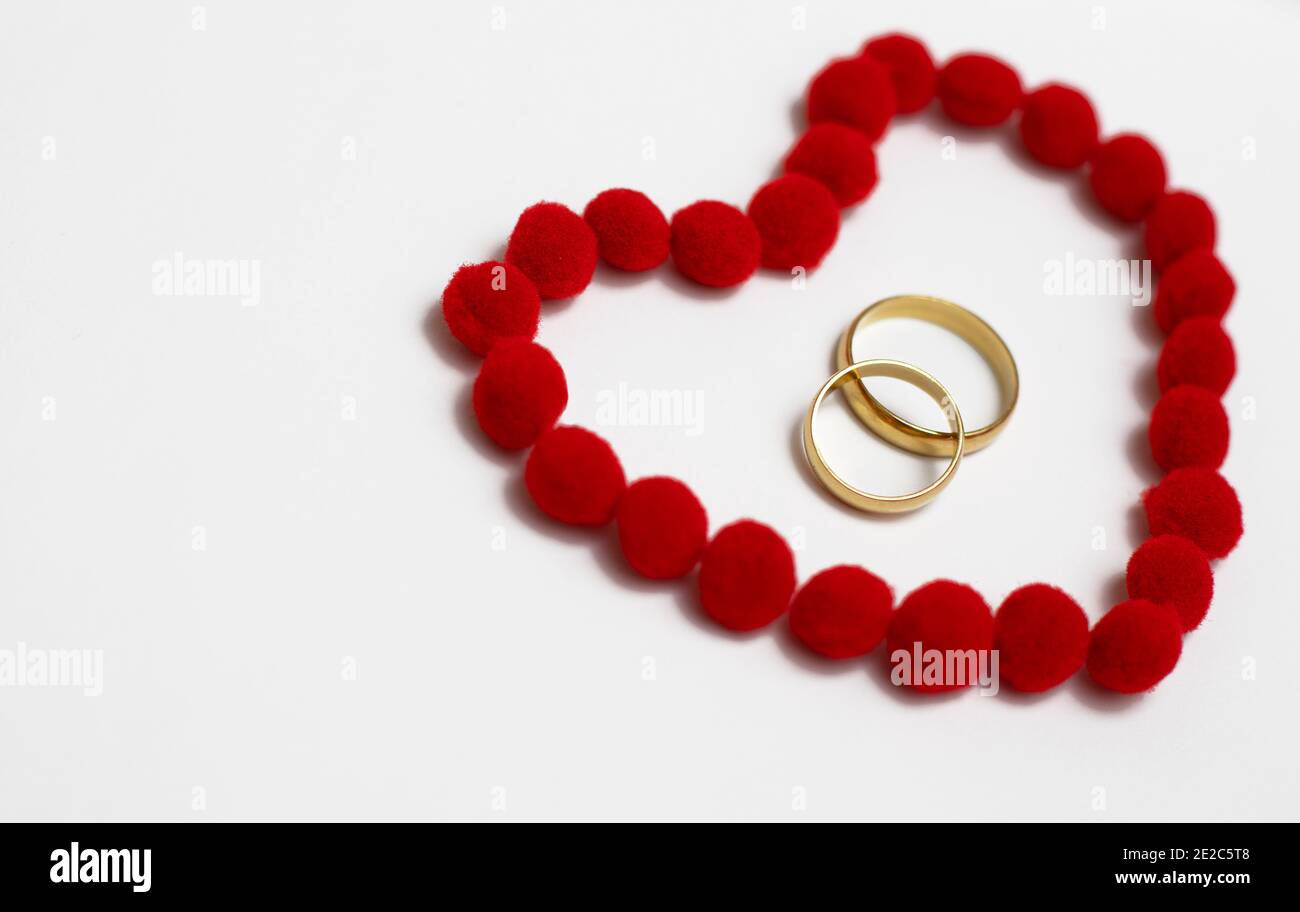 Anneaux de mariage dorés et cœur rouge. Anneaux de mariage sur fond ...