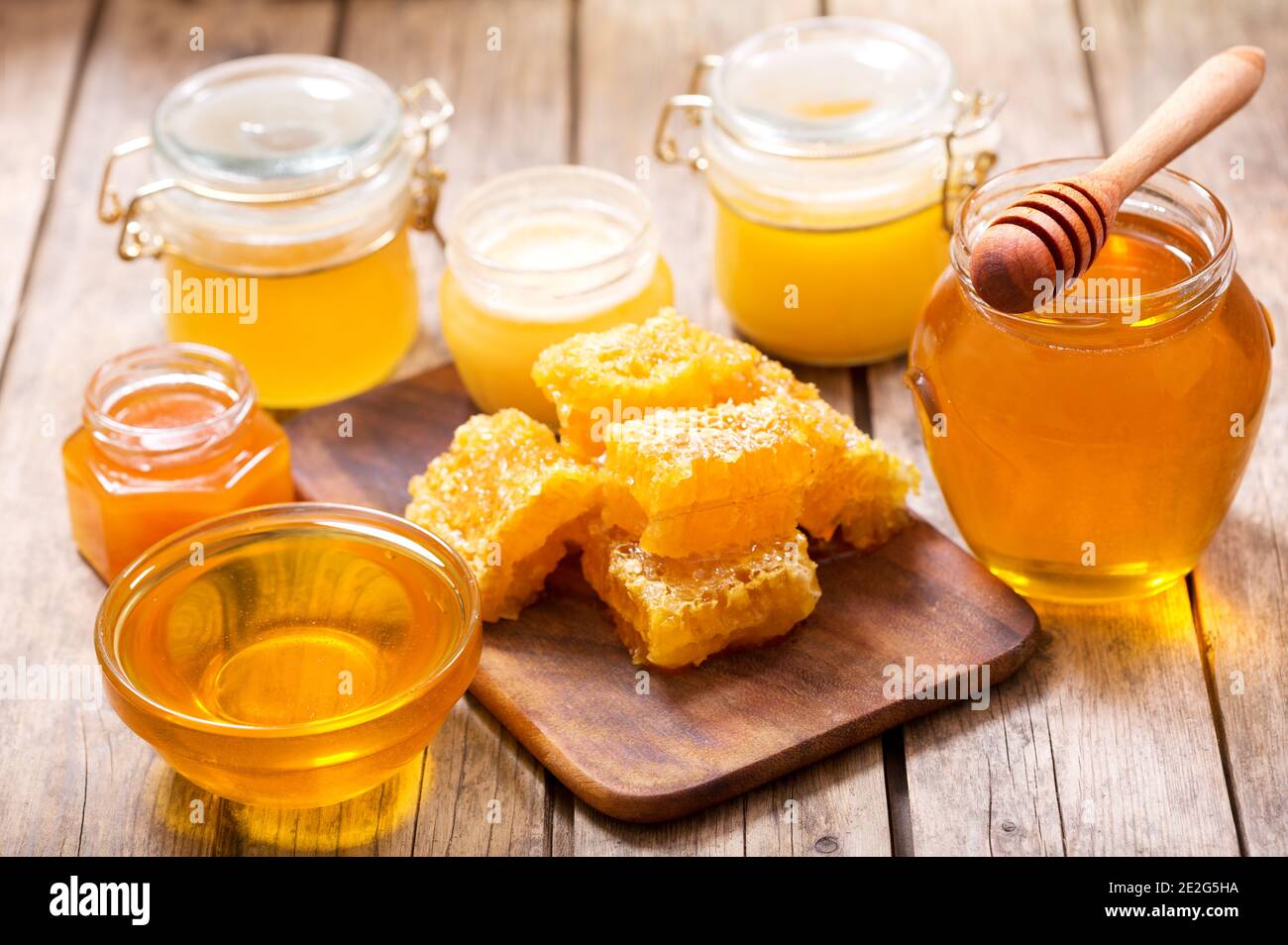 différents types de miel en pots de verre sur un bois tableau Photo ...