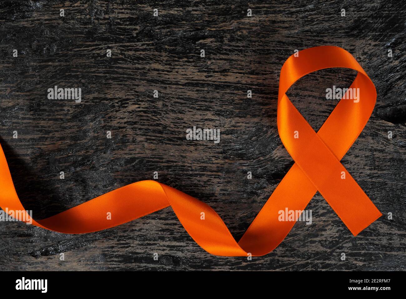 Vue de dessus du ruban orange sur fond de bois sombre. Leucémie, cancer ...