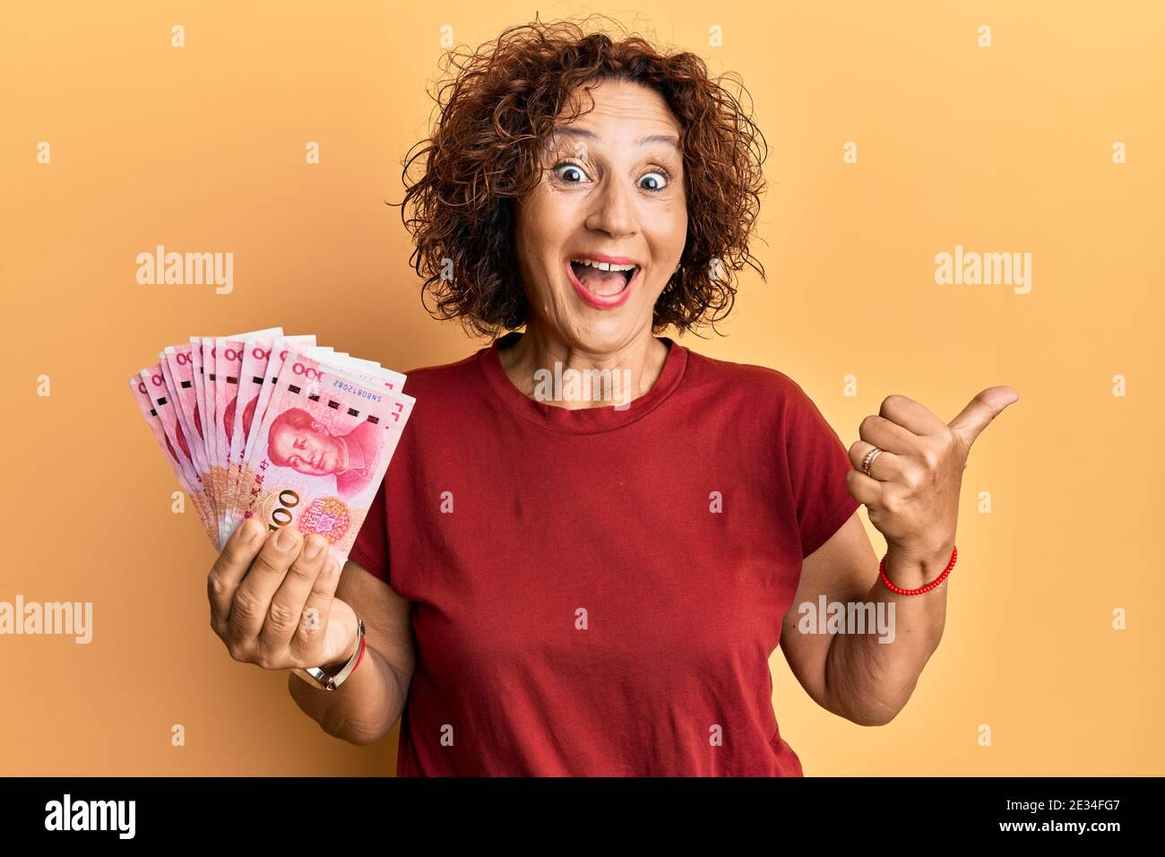 Belle femme mûre d'âge moyen détenant 100 yuan de billets chinois en ...
