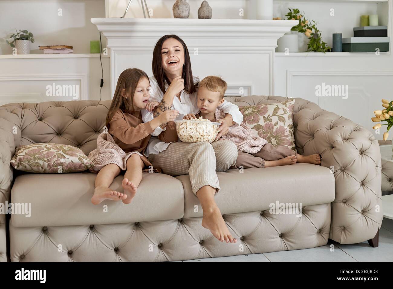 Maman S Assoit Sur Le Lit Avec Son Fils Et Sa Fille Et Regarde Un Film