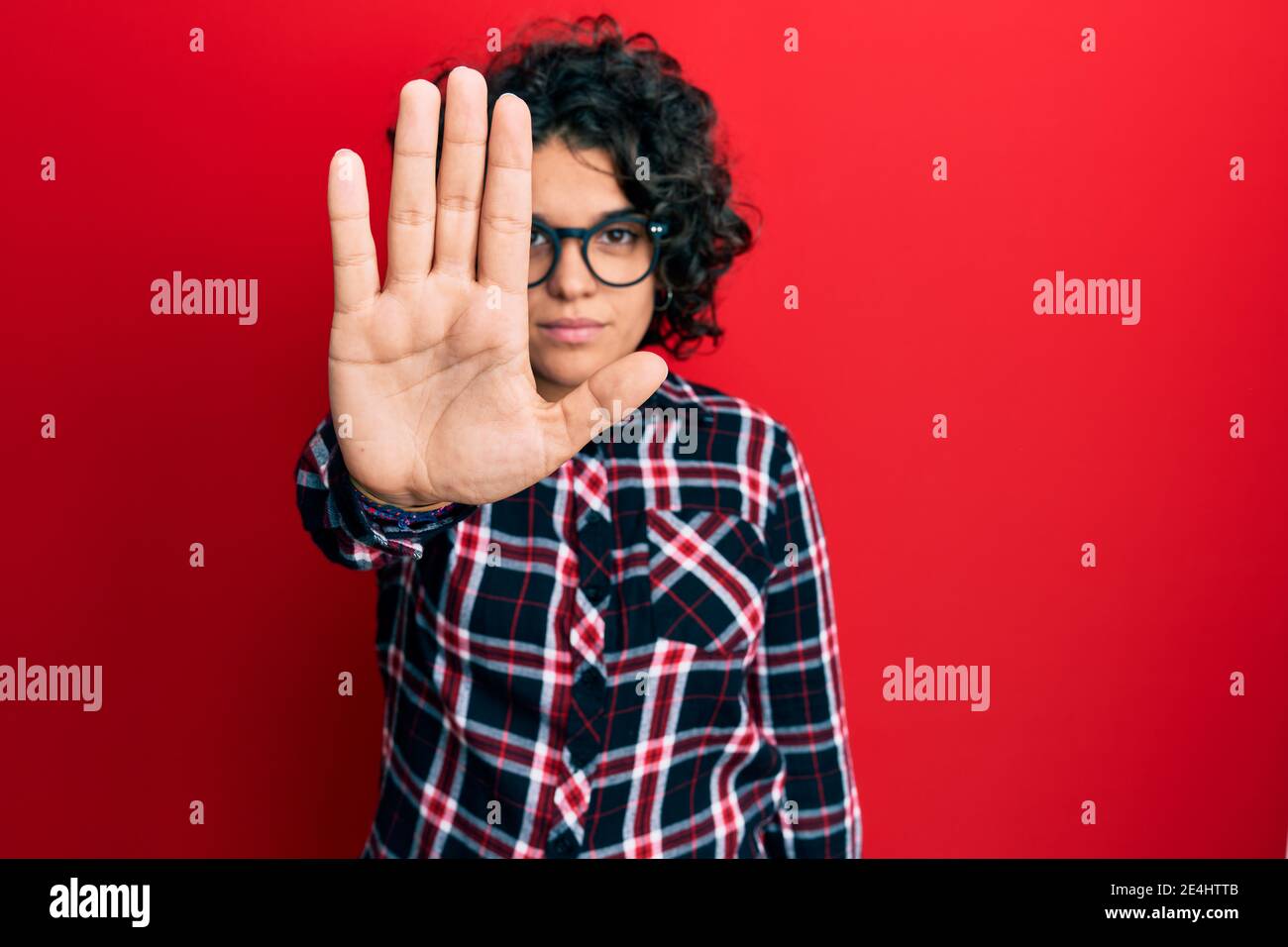 Jeune femme hispanique avec cheveux bouclés portant des vêtements et ...