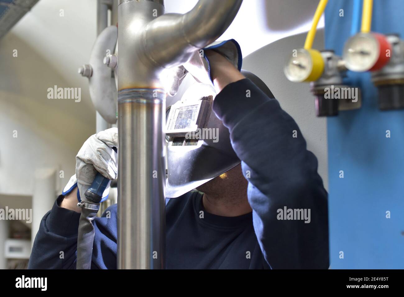 le soudeur travaille dans la construction d'acier et répare une usine ...