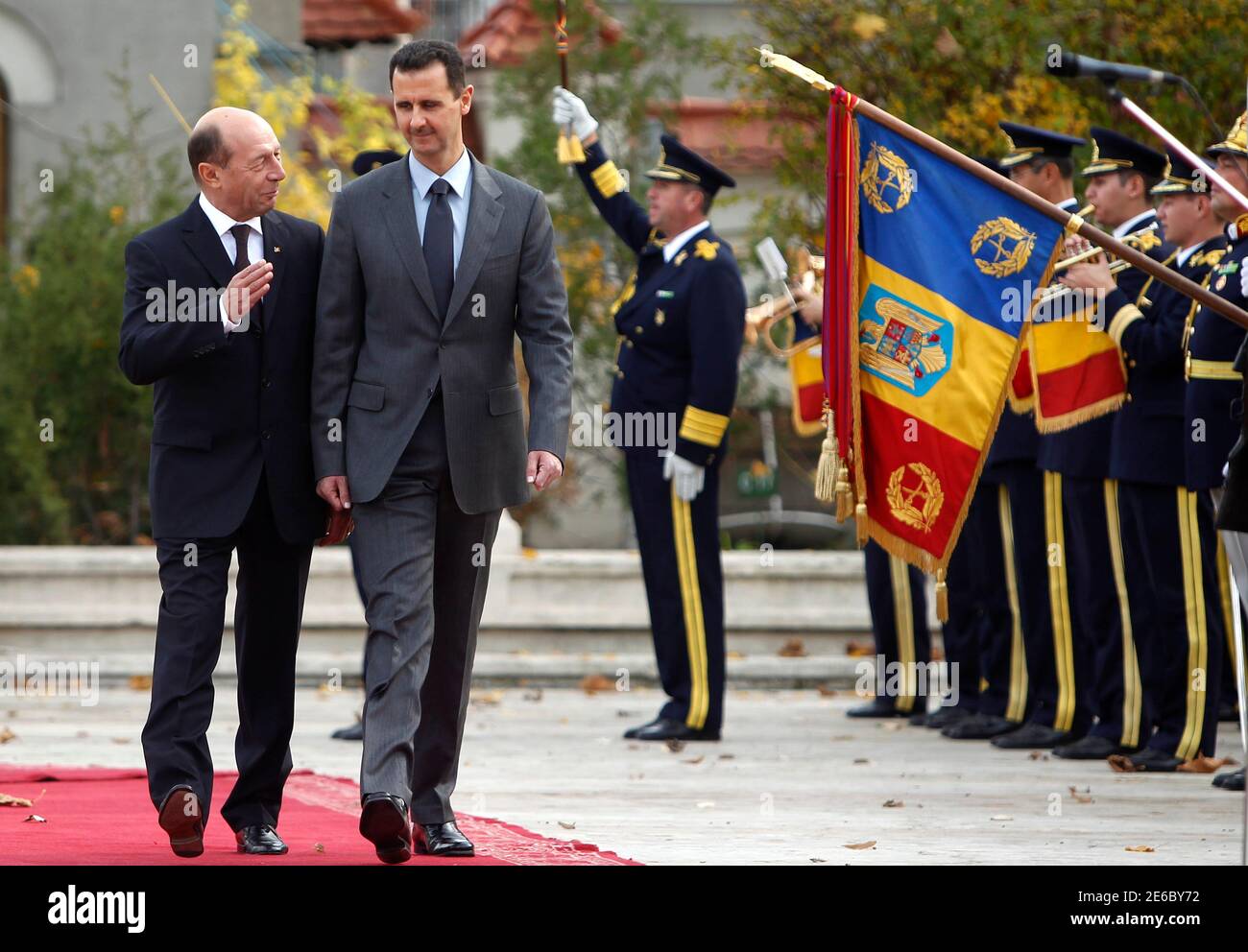 Romania's President Traian Basescu (L) and Syria's President Bashar al-Assad review an honour ...