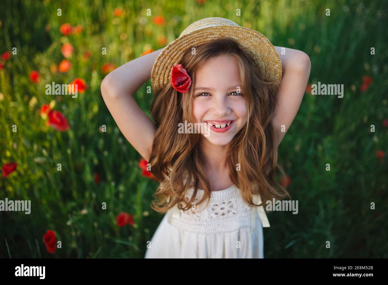 jolie petite fille dans un pré avec des coquelicots rouges Photo Stock ...