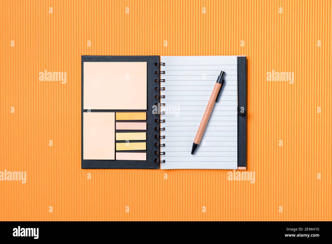 Carnet scolaire sur fond de papier orange, bloc-notes en spirale et ...