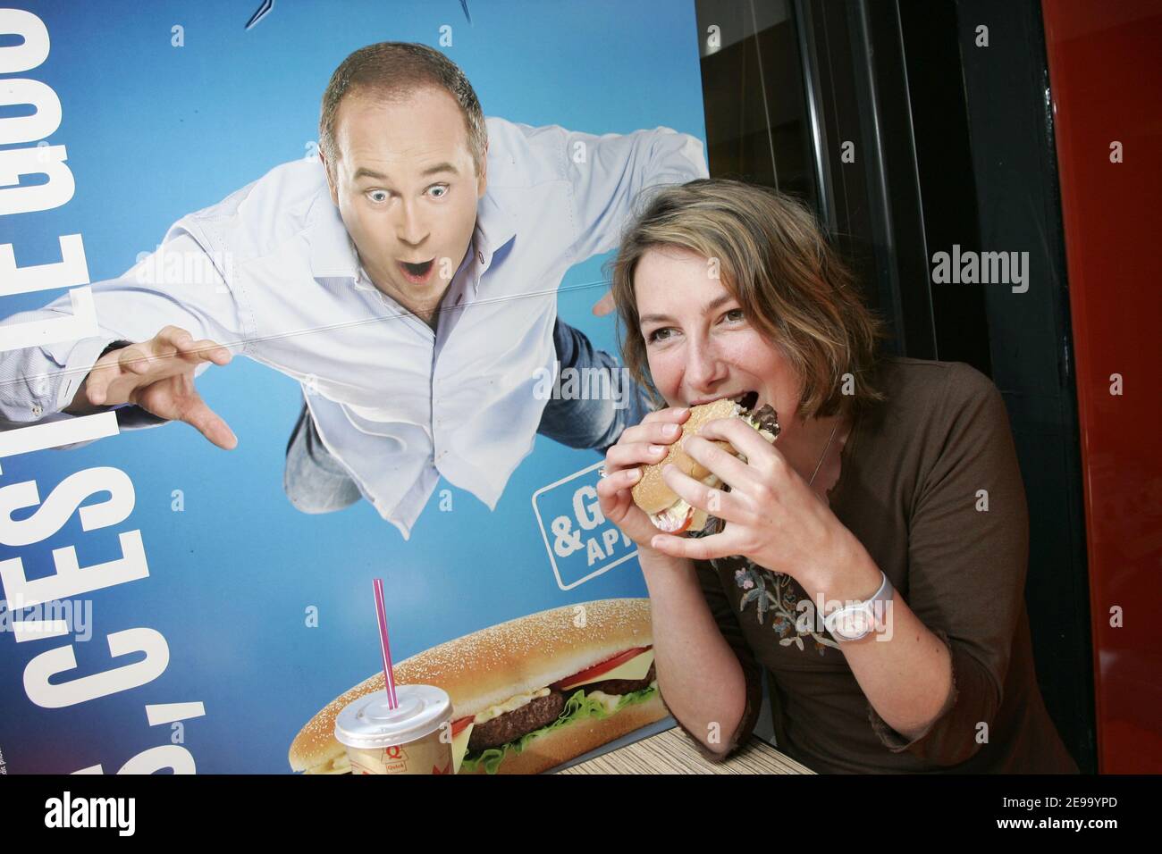 Une jeune dame apprécie le nouveau « Cauet Burger » (nommé d'après l ...