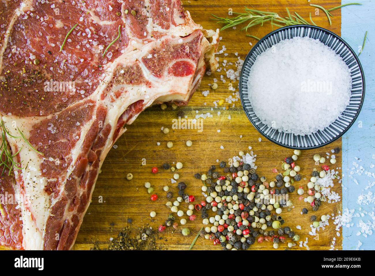 Tranche de viande de bœuf crue sur la table avec du romarin et d'autres ...