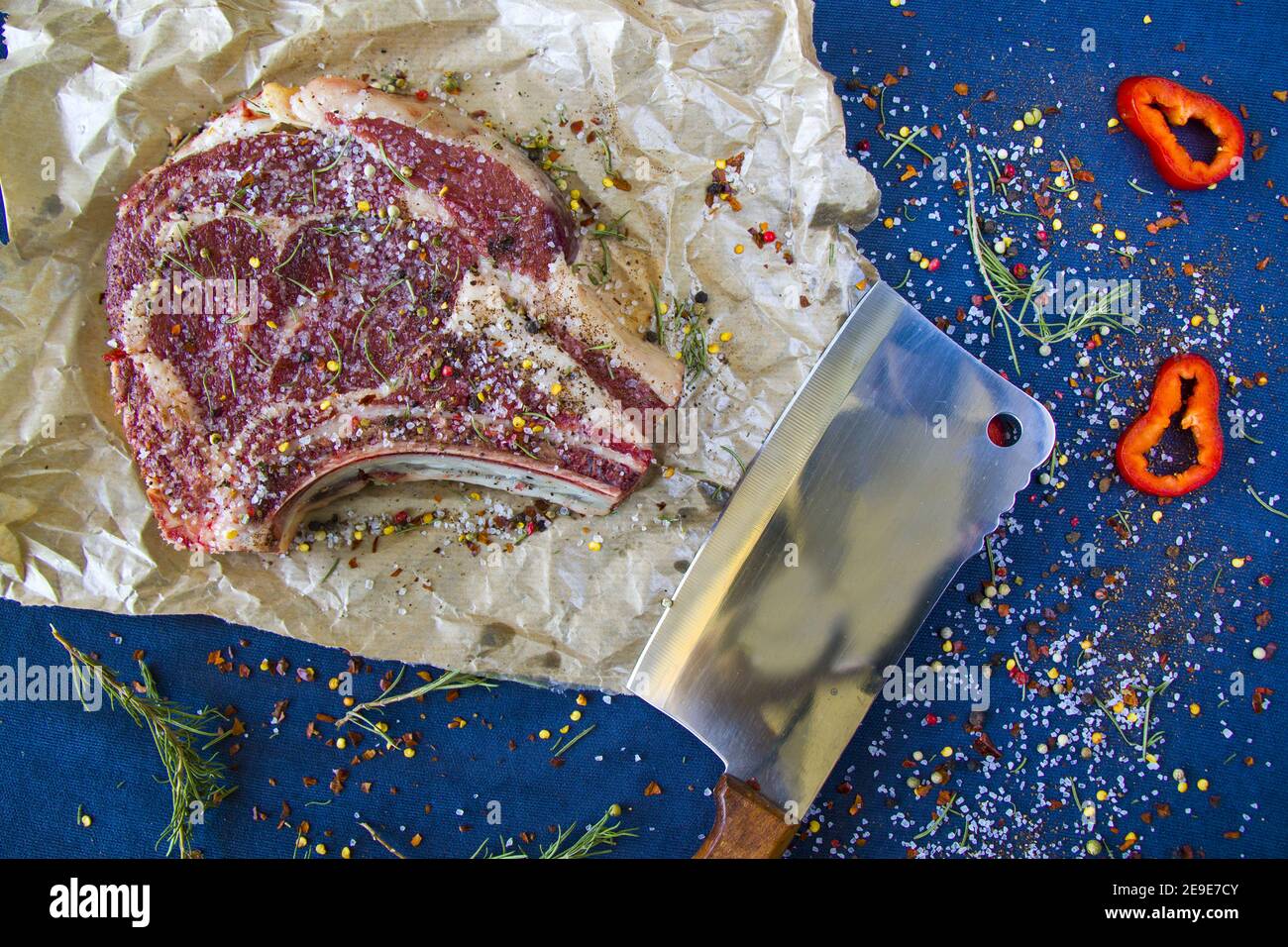 Tranche de viande de bœuf crue sur la table avec du romarin et d'autres ...