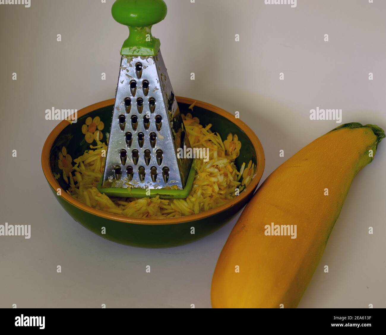 bol en faïence avec râpe à légumes et courgettes jaunes, plats faits ...