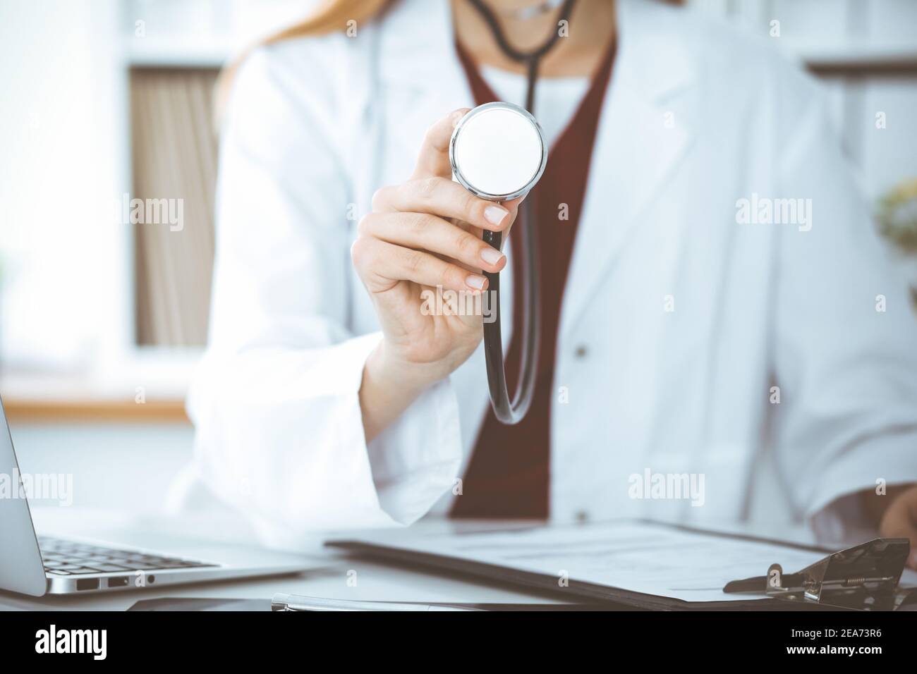 Femme-médecin inconnue avec un stéthoscope dans les mains. Le médecin ...