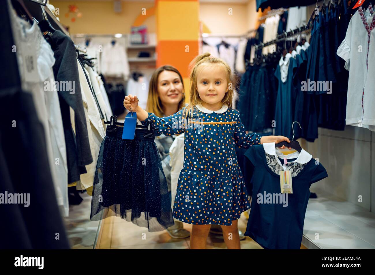 La mère et le petit bébé choisissent la jupe, magasin pour enfants ...