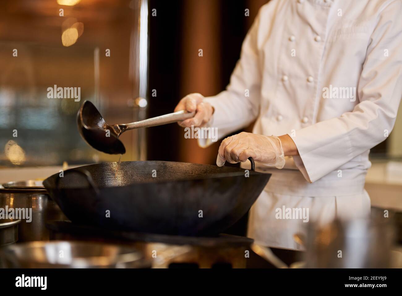Photo rognée d'un chef en uniforme blanc tenant un louche en se tenant ...
