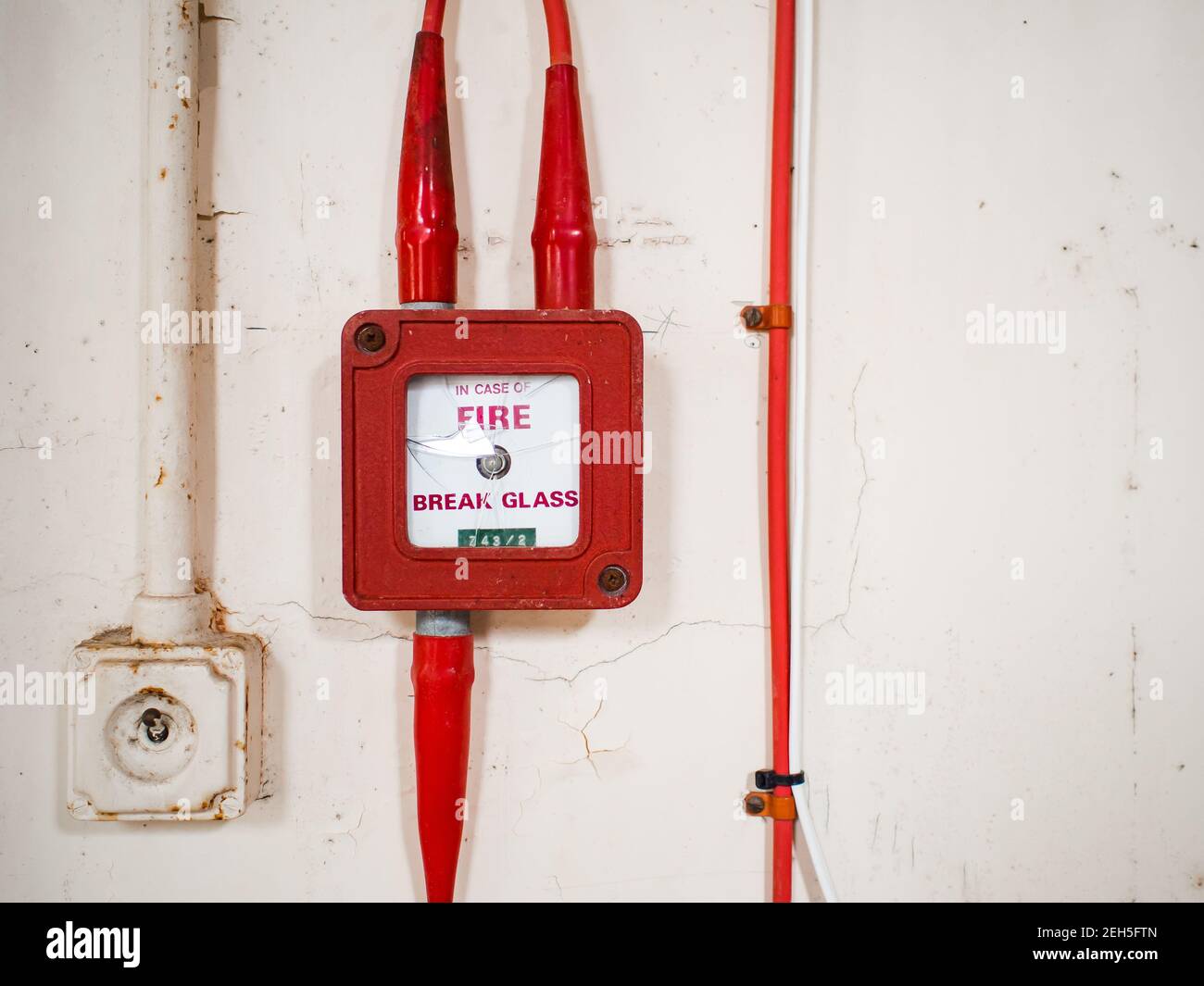 Bouton-poussoir d'activation de l'alarme incendie en métal rouge cassé ...