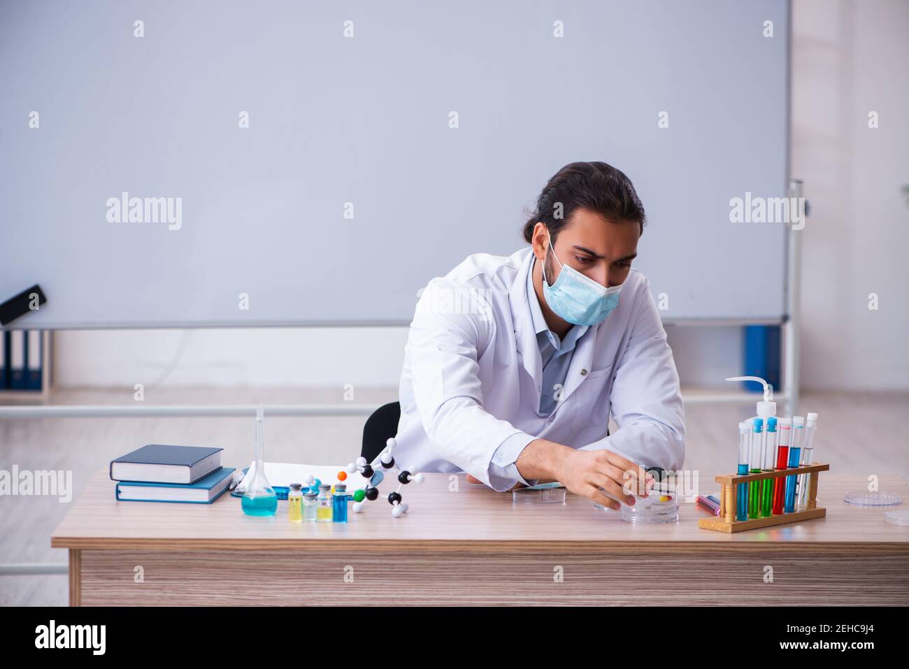 Jeune professeur de chimiste assis dans la salle de classe Photo Stock ...