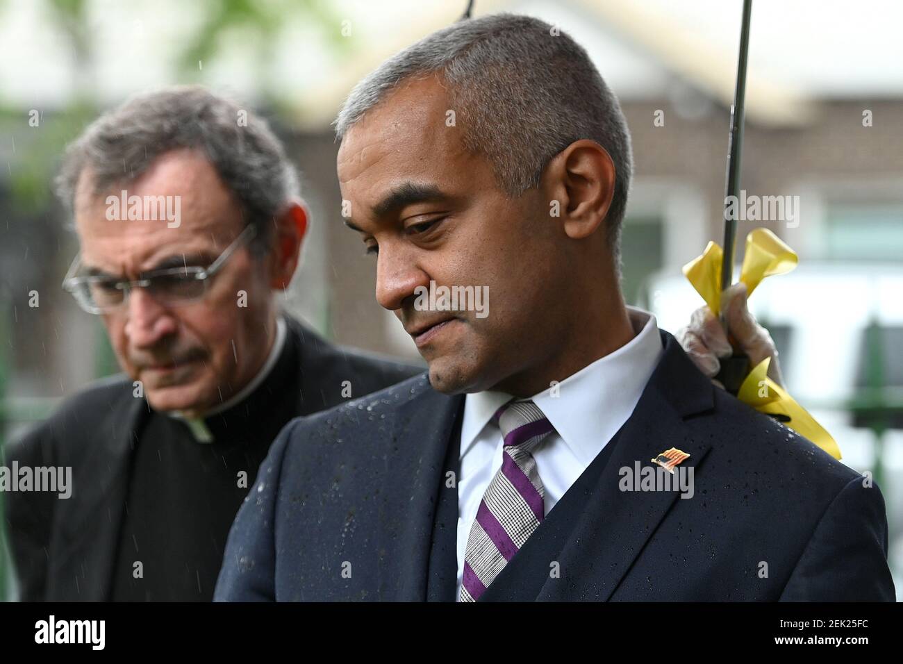 Flanqué de Monseigneur Joseph Calise (l) le directeur funéraire Omar ...