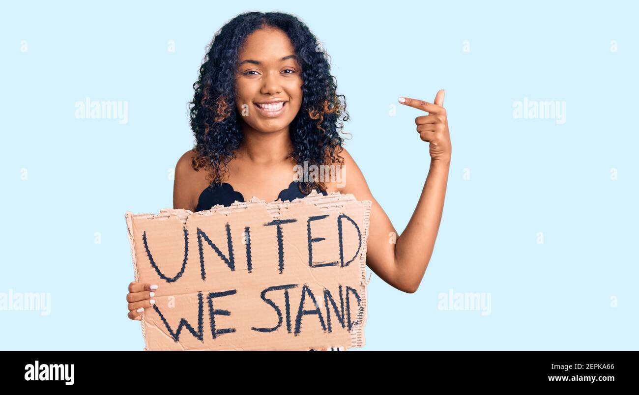Une jeune femme afro-américaine qui tient uni, nous sommes en position de drapeau un seul ...