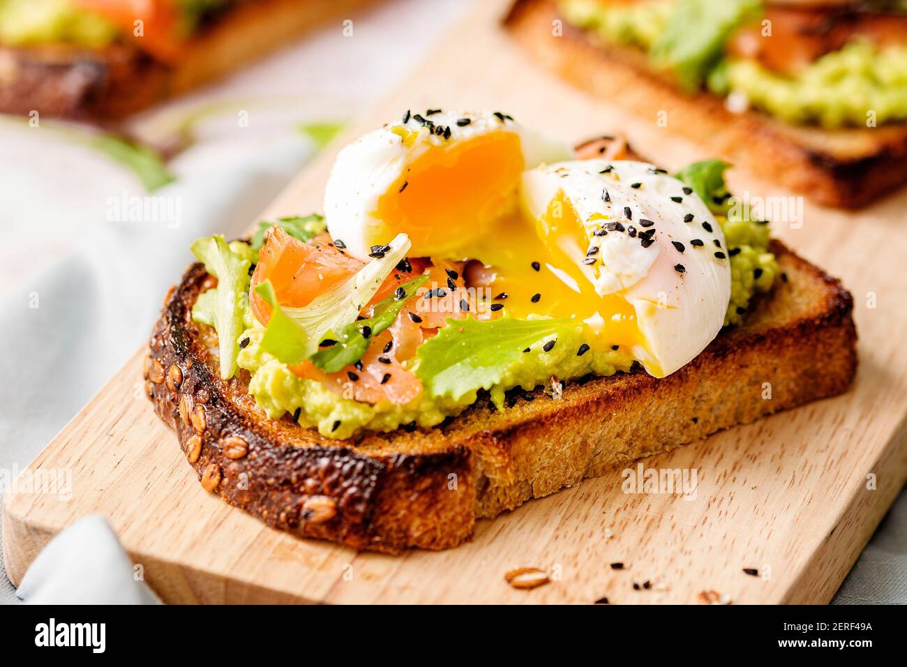 Toast au saumon fumé avec crème d'avocat et œuf poché ouvert sur le ...