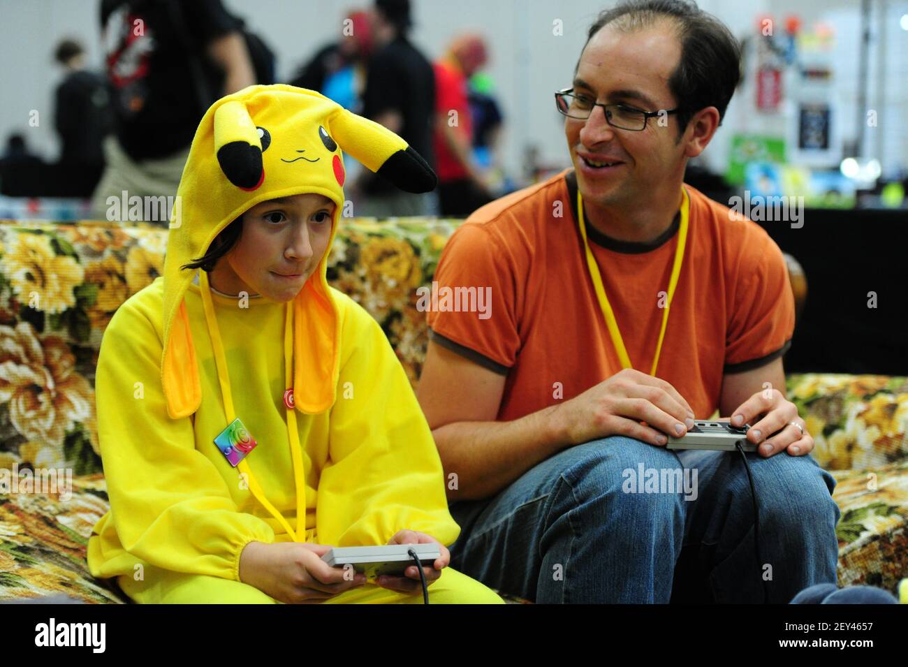 Un garçon habillé comme Pikachu joue Mario Bros/ avec son père à la ...