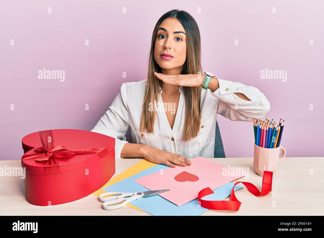 Une jeune femme hispanique faisant du cadeau de Valentin assise sur la ... Une jeune femme hispanique faisant du cadeau de Valentin assise sur la ...