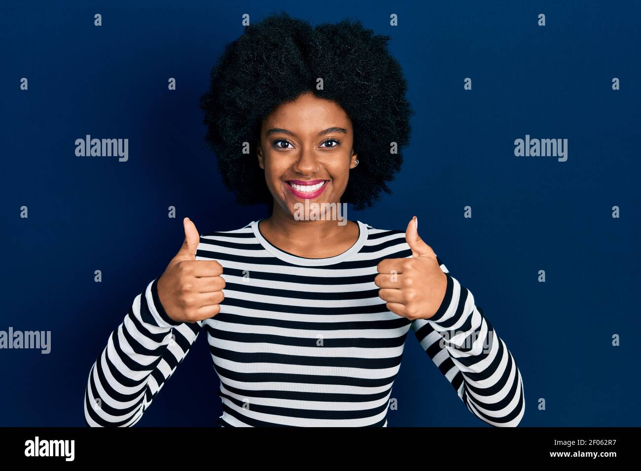 Jeune afro-américaine vêtue décontracté signe de réussite faire un ...