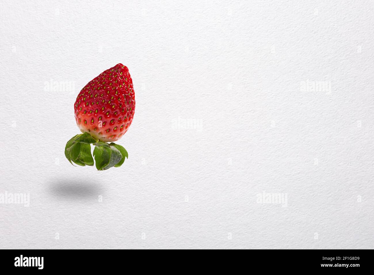 Une belle fraise rouge fraîche entière avec effet de lévitation et avec ...
