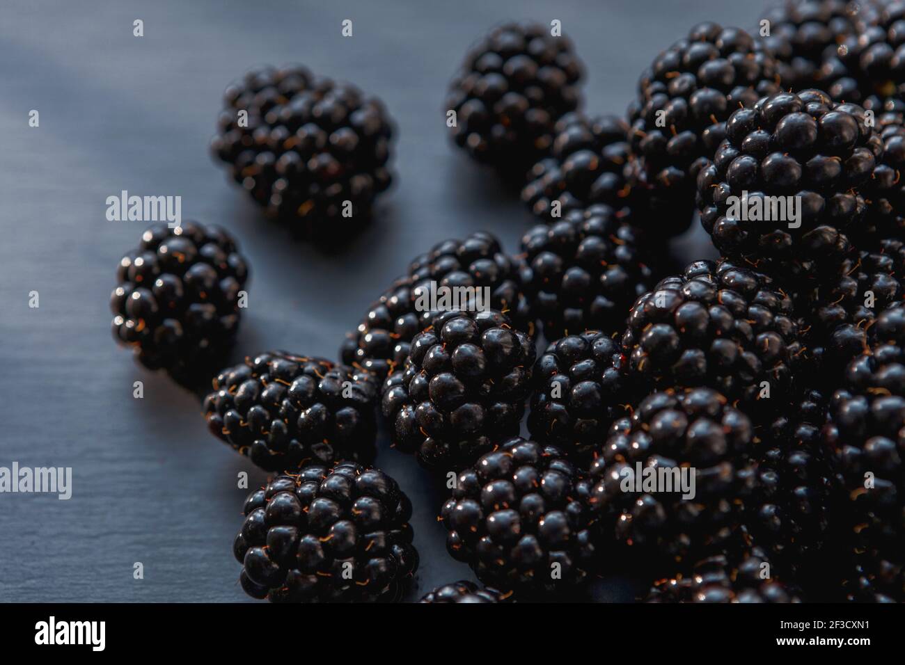 Gros plan sur des fruits mûrs juteux et savoureux, sur une table grise ...