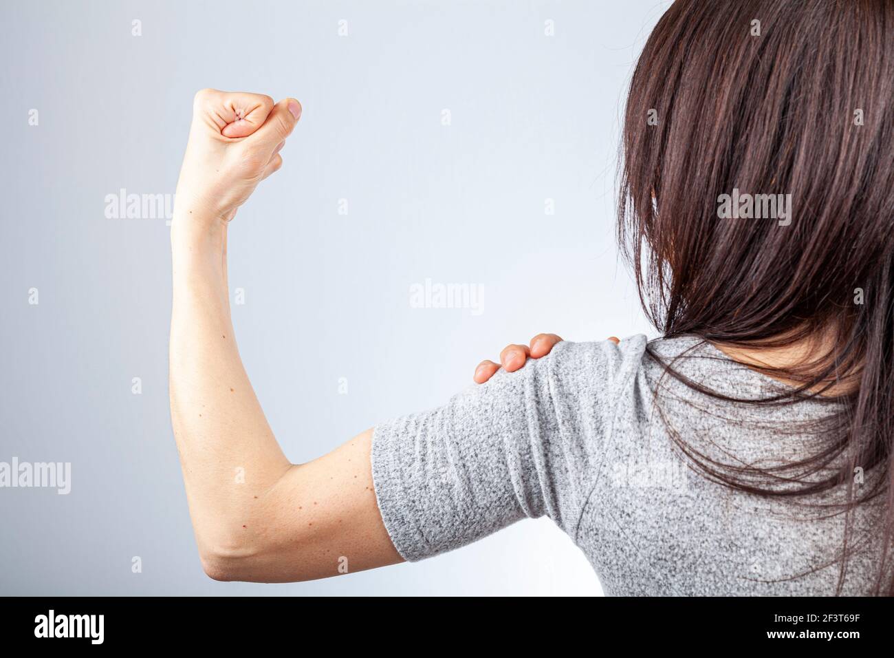 une femme montre son poing et les muscles de son avant-bras et de son ...