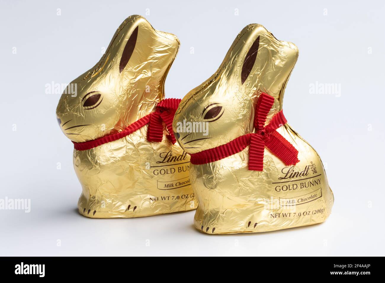 Deux lapins d'or Lindt isolés sur un fond blanc. Chocolat au lait ...